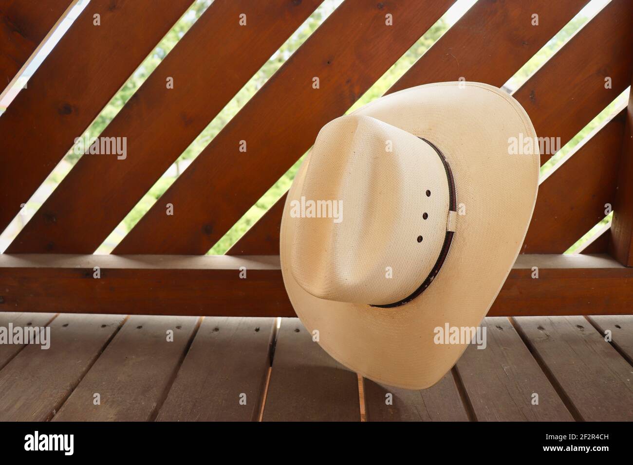 Cowboy hand leaning against wooden boards on a balcony Stock Photo - Alamy
