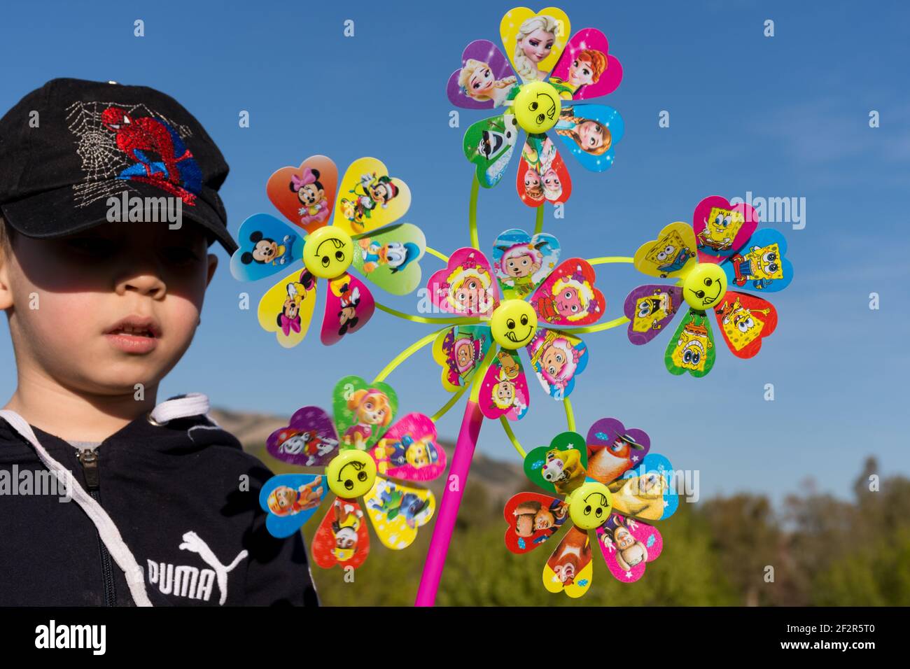 Front view of a young boy holding a colorful pinwheel toy Stock Photo ...