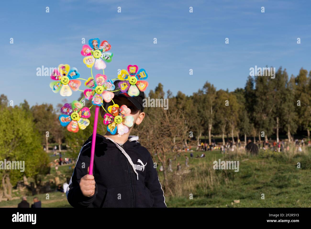 Front view of a young boy holding a colorful pinwheel toy Stock Photo ...