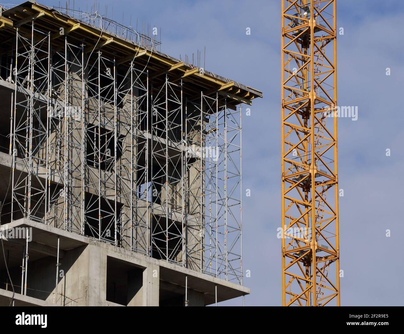Building crane at the background of a multi-storey building under ...