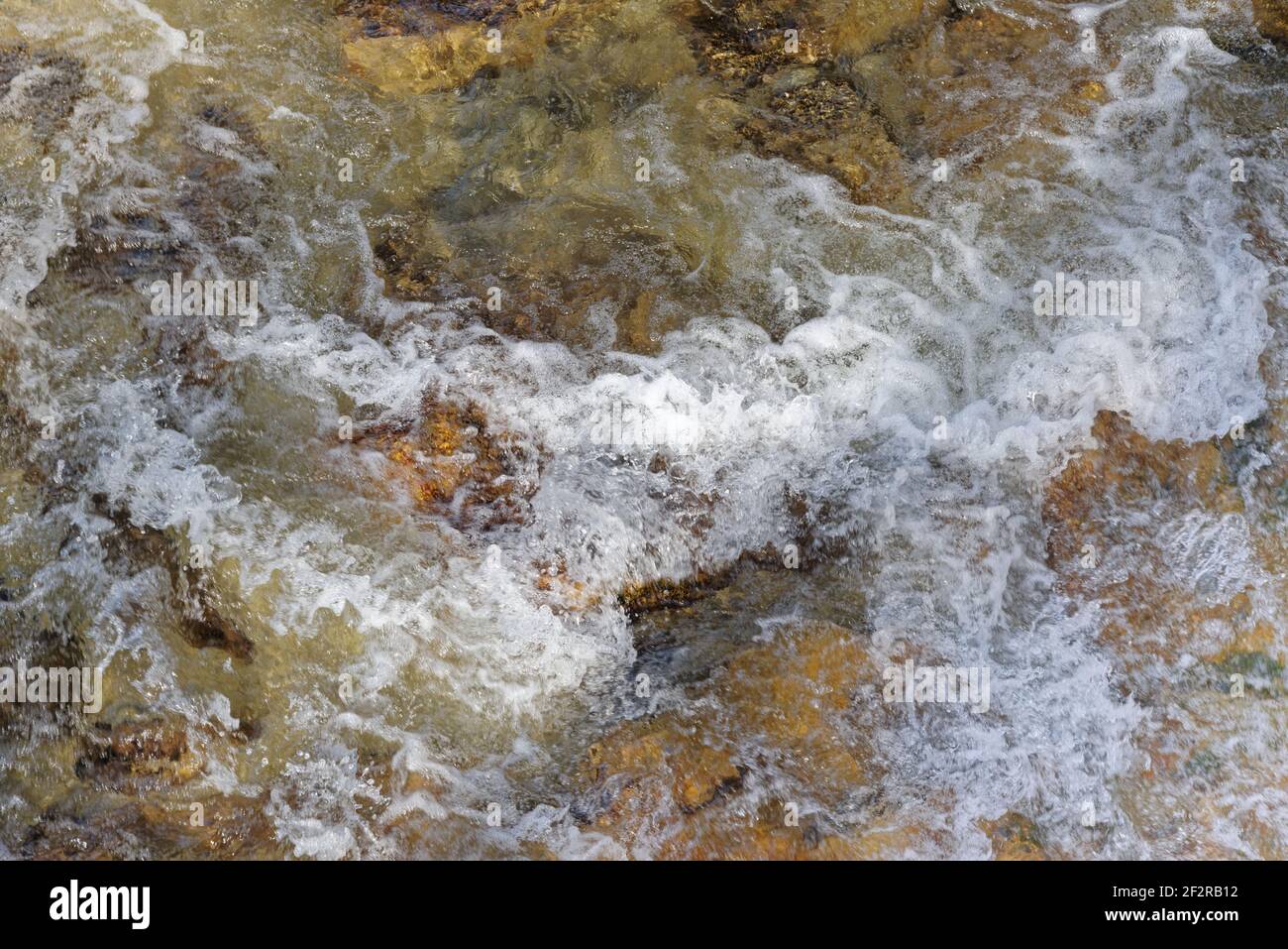 Directly above view of bright flowing water of the river. Full frame ...