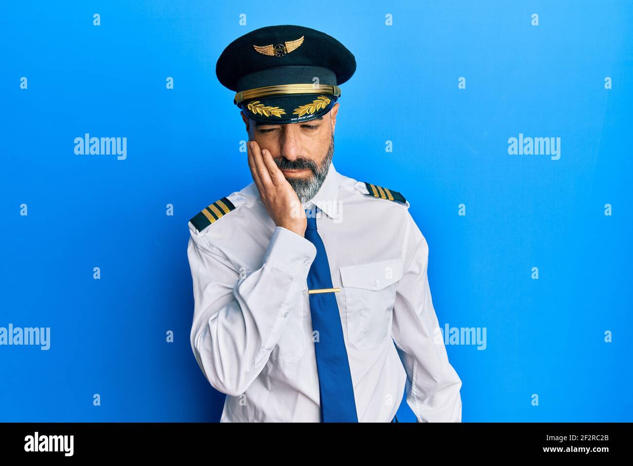 Middle age man with beard and grey hair wearing airplane pilot uniform ...