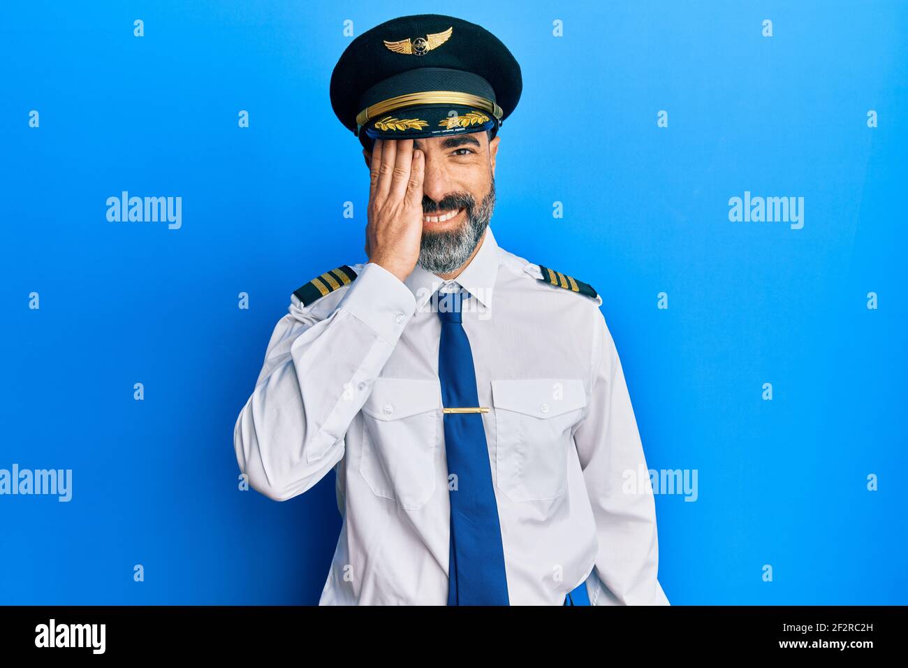 Middle age man with beard and grey hair wearing airplane pilot uniform ...