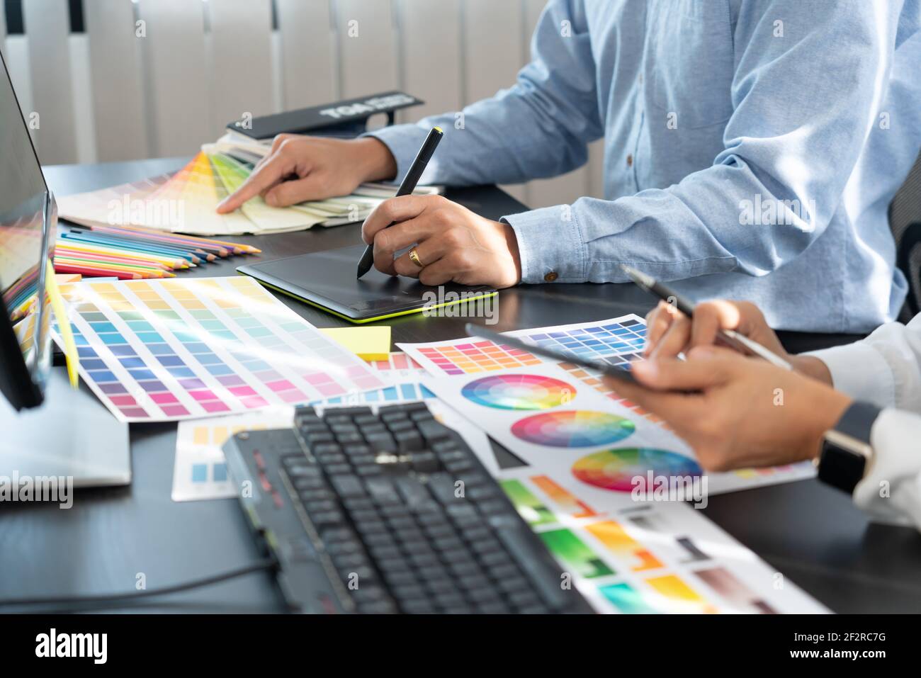 graphic designer team working on web design using color swatches ...