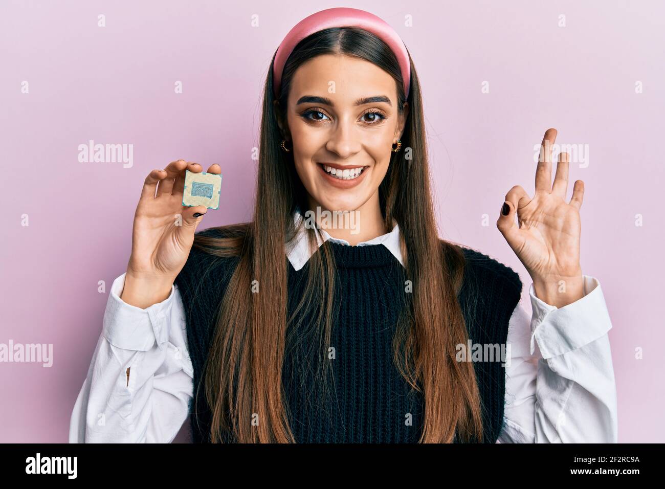 Beautiful brunette young woman holding cpu processor computer doing ok ...