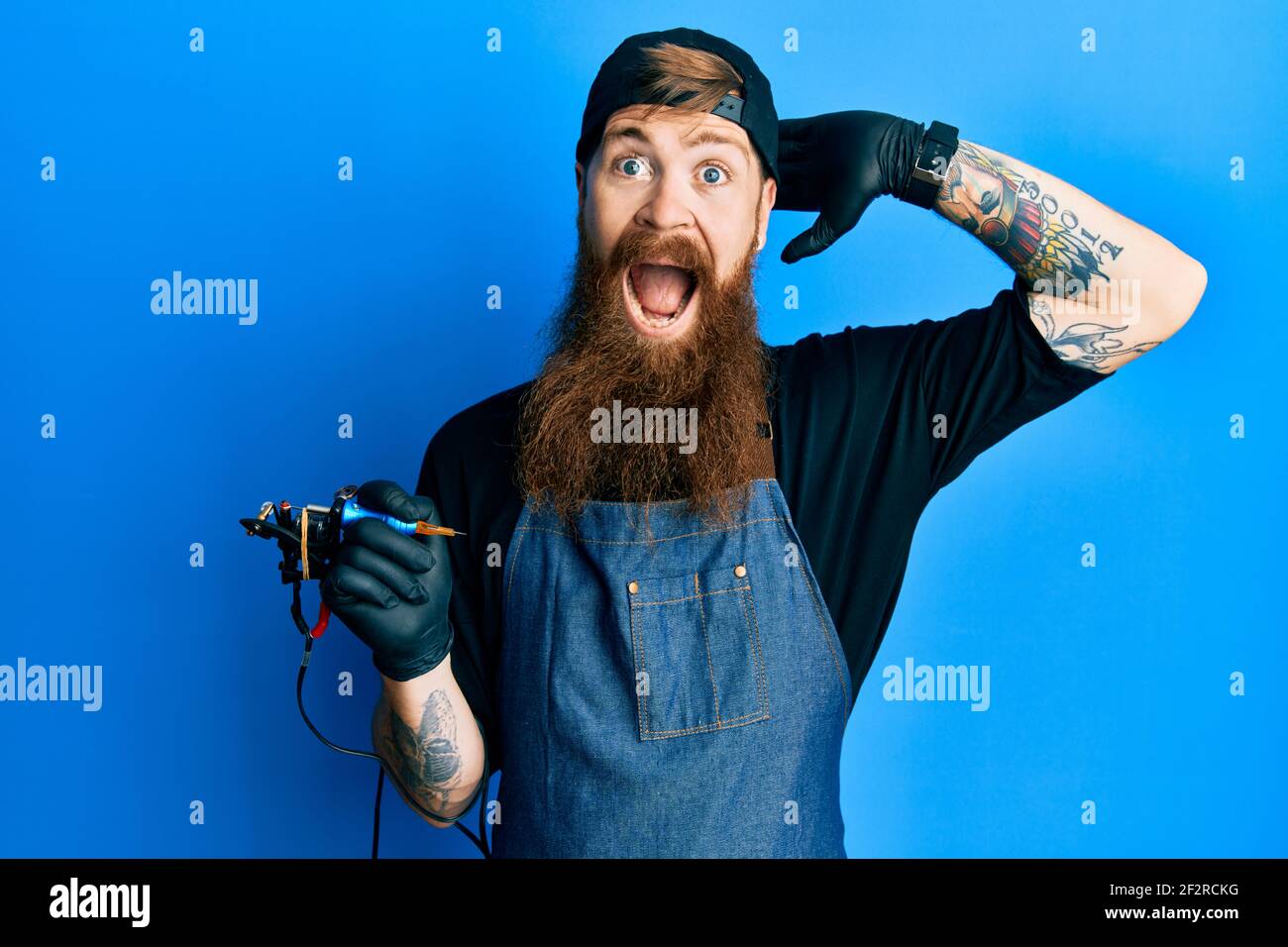 Redhead man with long beard tattoo artist wearing professional uniform ...