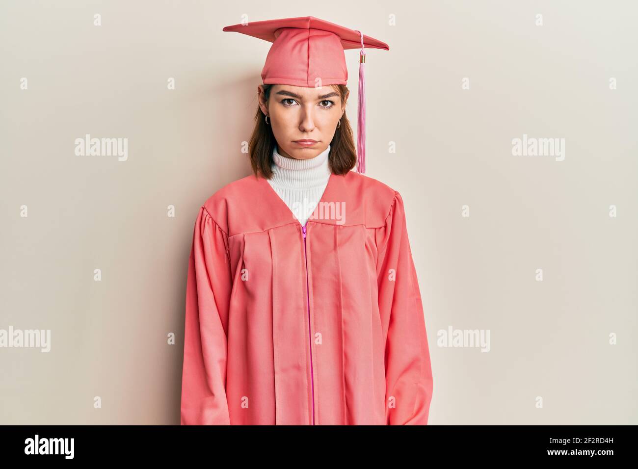 Young caucasian woman wearing graduation cap and ceremony robe ...