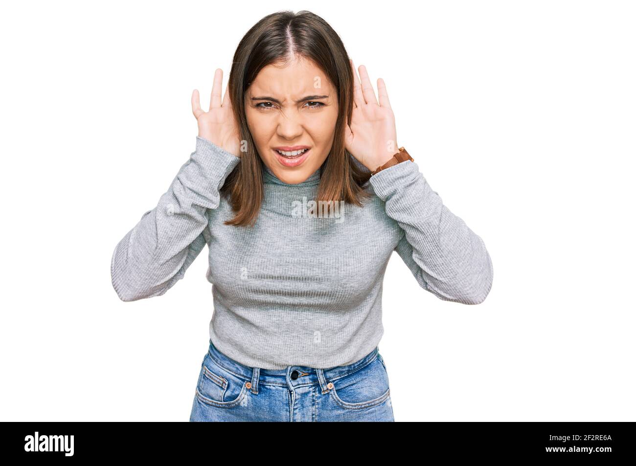 Young beautiful woman wearing casual turtleneck sweater trying to hear ...