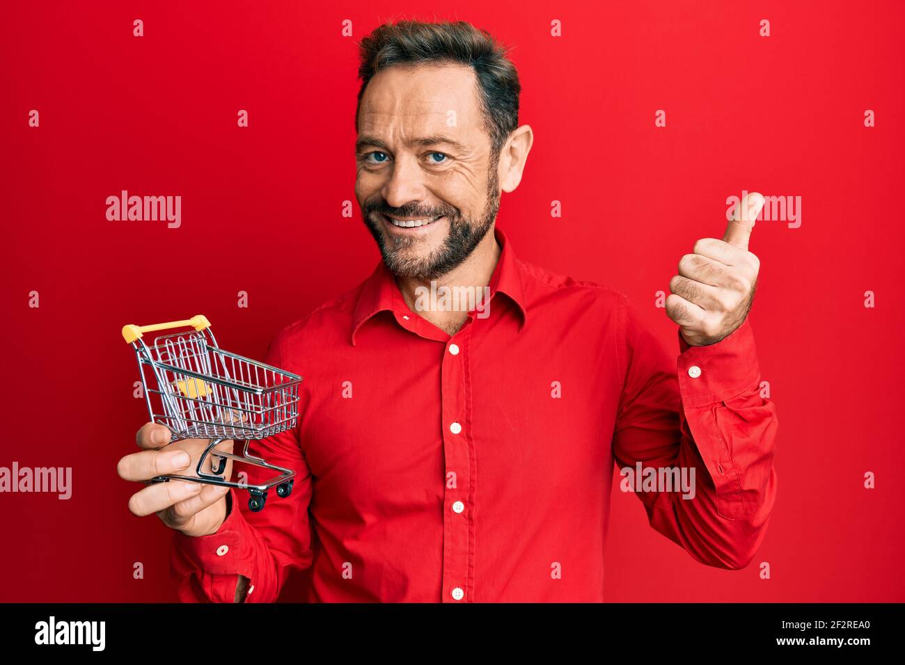 Middle age man holding small supermarket shopping cart smiling happy ...