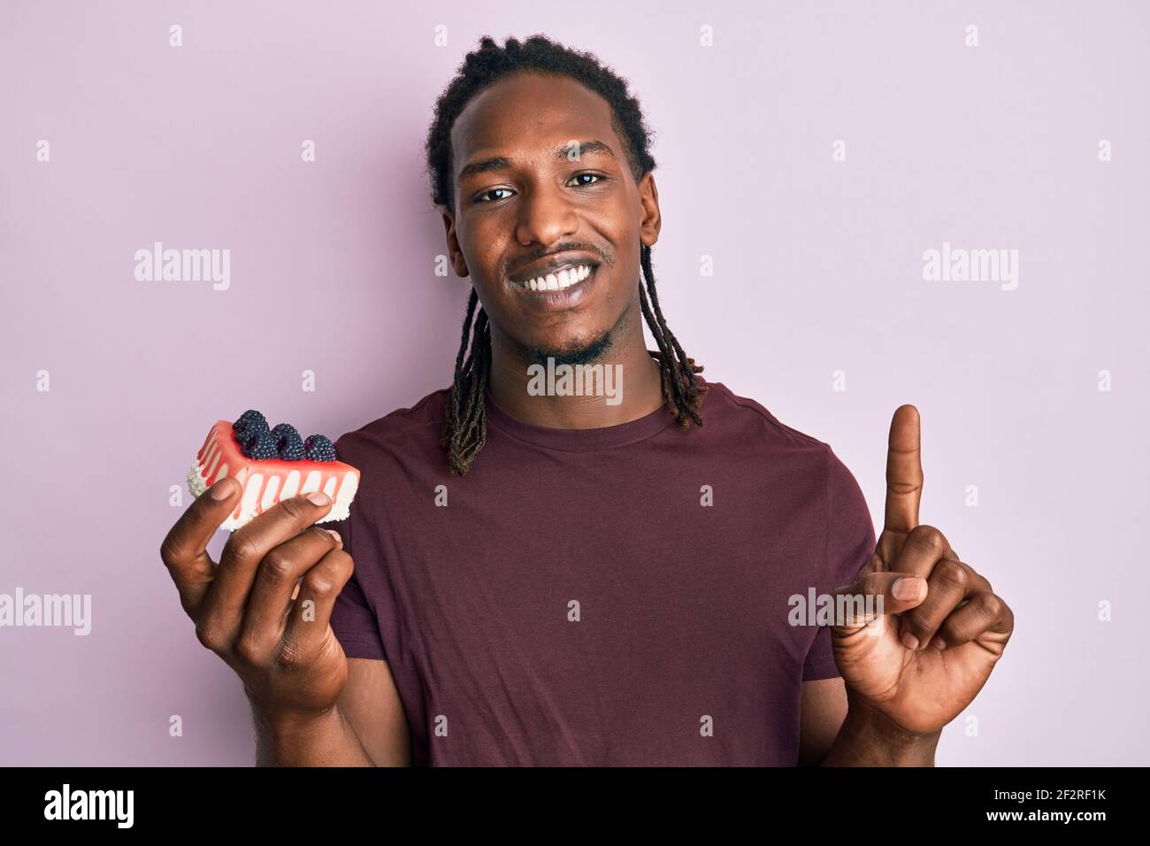 African american man with braids holding plate with cheesecake smiling ...