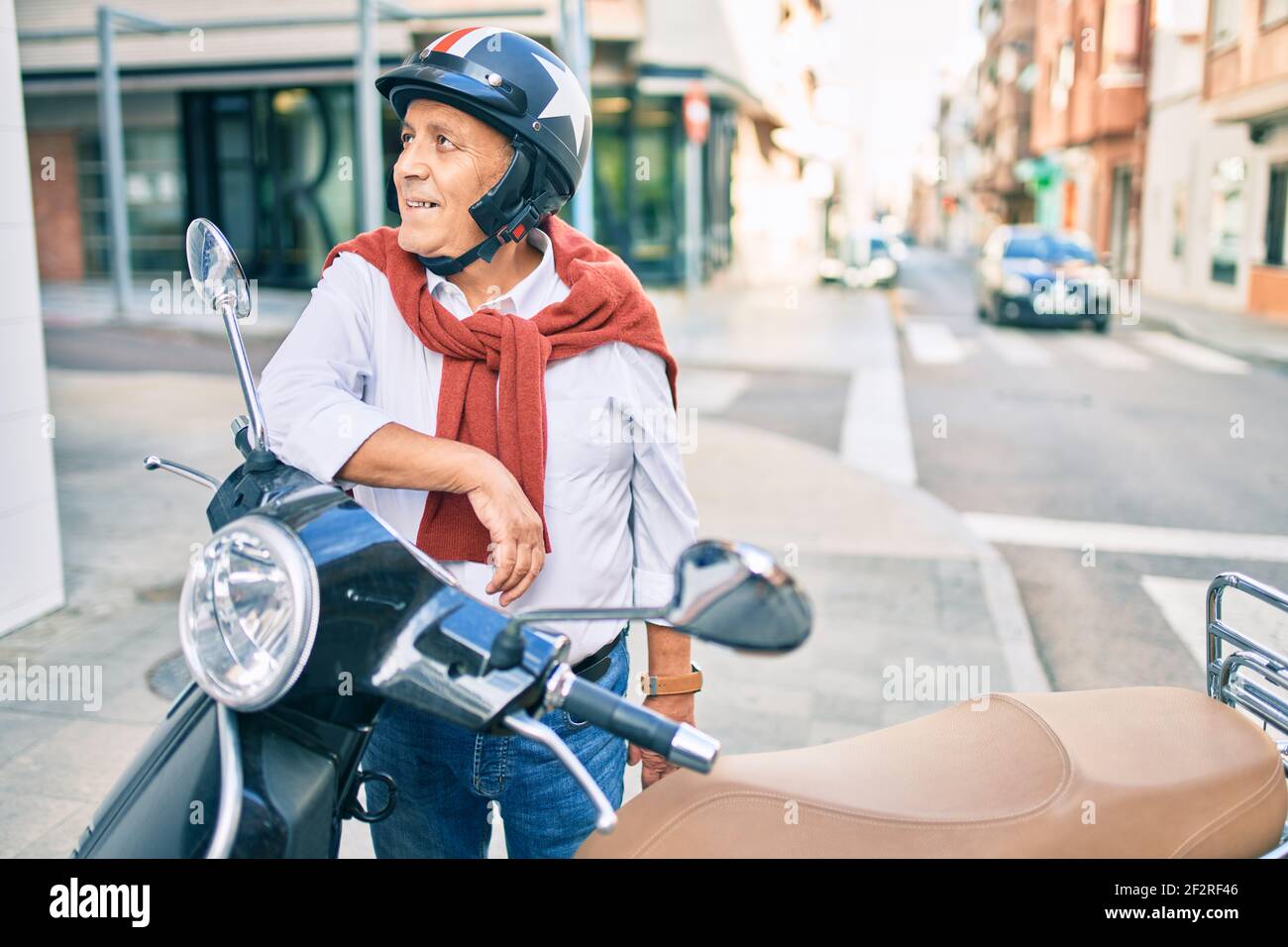 Senior motorcyclist man smiling happy wearing moto helmet at the city ...