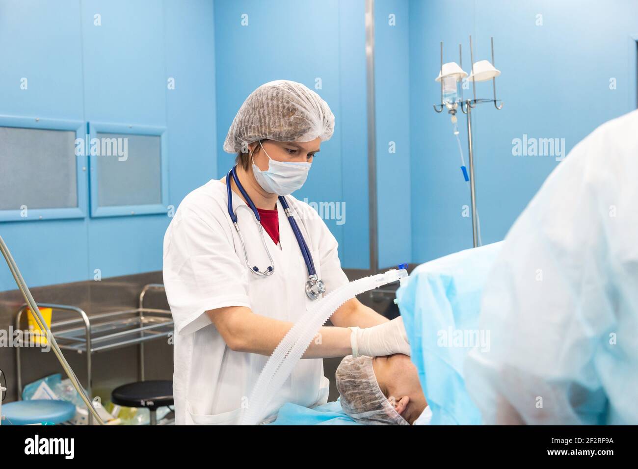 Portrait of an anesthesiologist among a team of doctors monitors ...