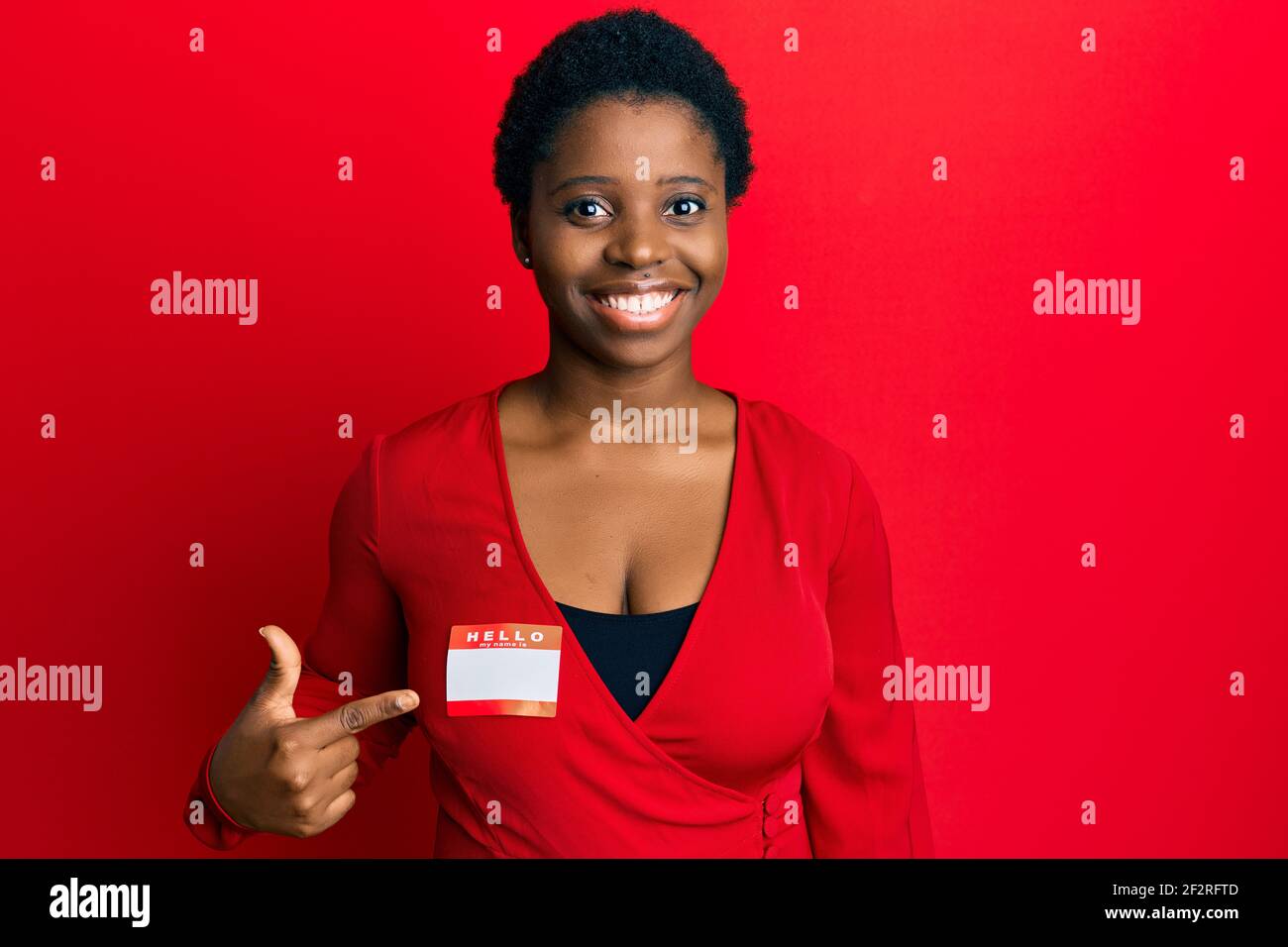 Young african woman with short hair wearing hello my name is sticker ...