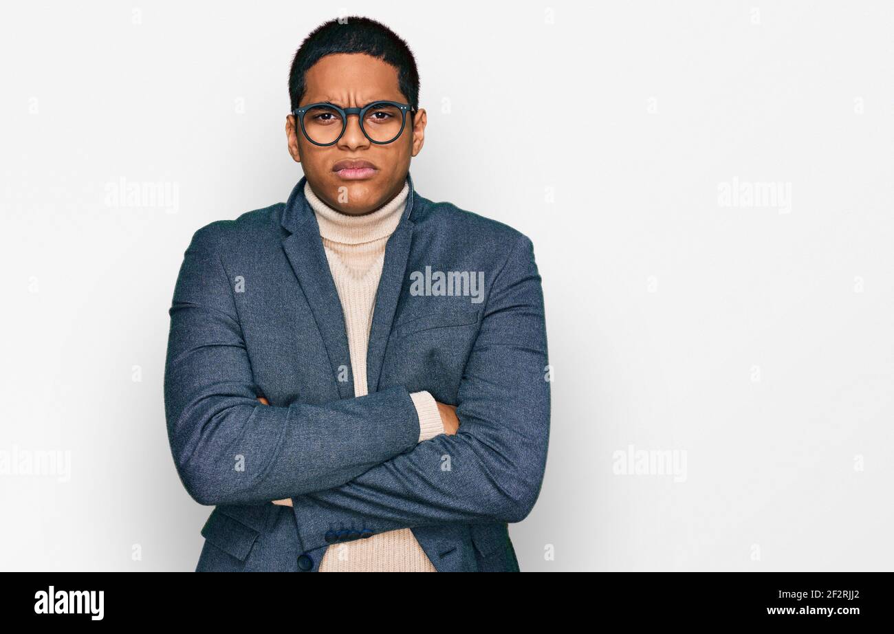 Young handsome hispanic man wearing business jacket and glasses skeptic ...