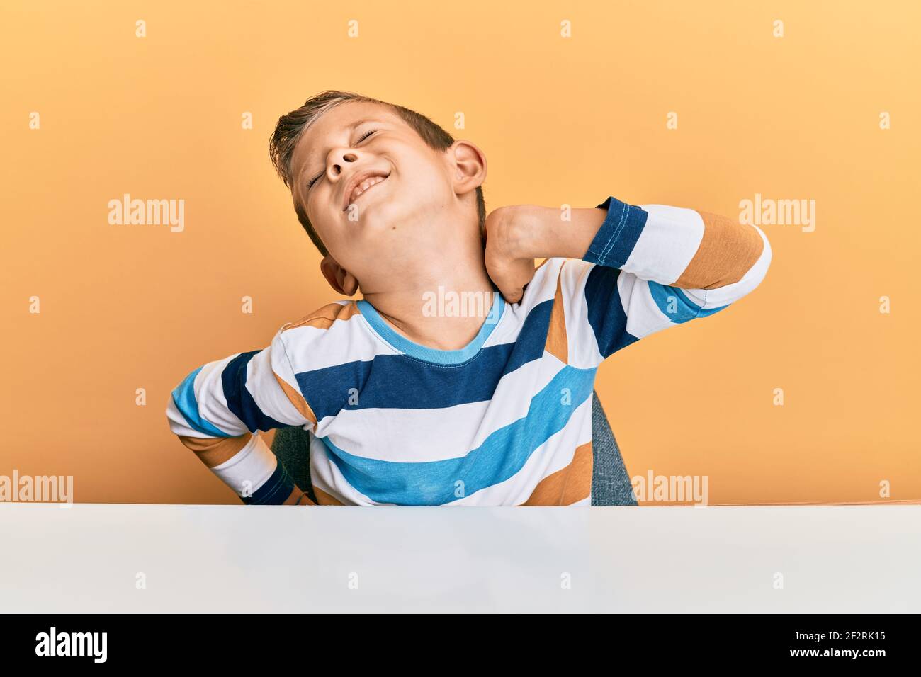 Adorable caucasian kid wearing casual clothes sitting on the table ...