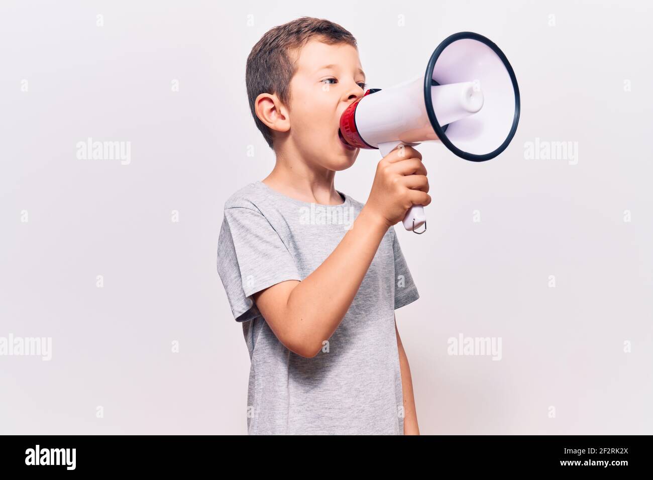 Adorable caucasian kid boy with angry expression. Screaming loud using ...