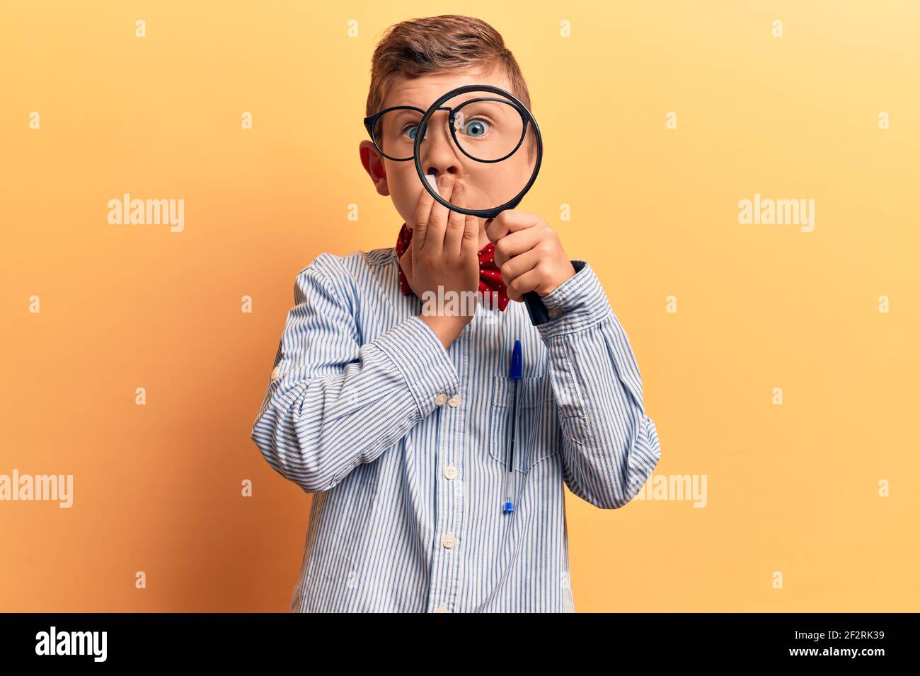 Cute blond kid wearing nerd bow tie and glasses holding magnifying ...