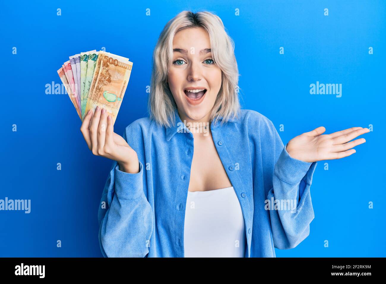 Young blonde girl holding philippine peso banknotes celebrating ...