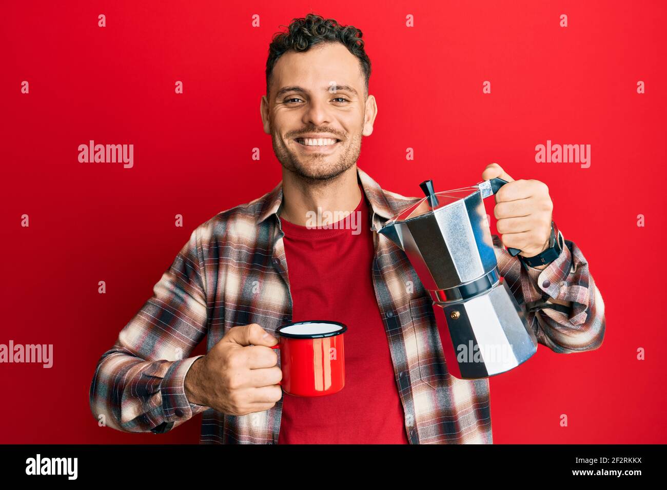 Young hispanic man drinking italian coffee smiling with a happy and ...