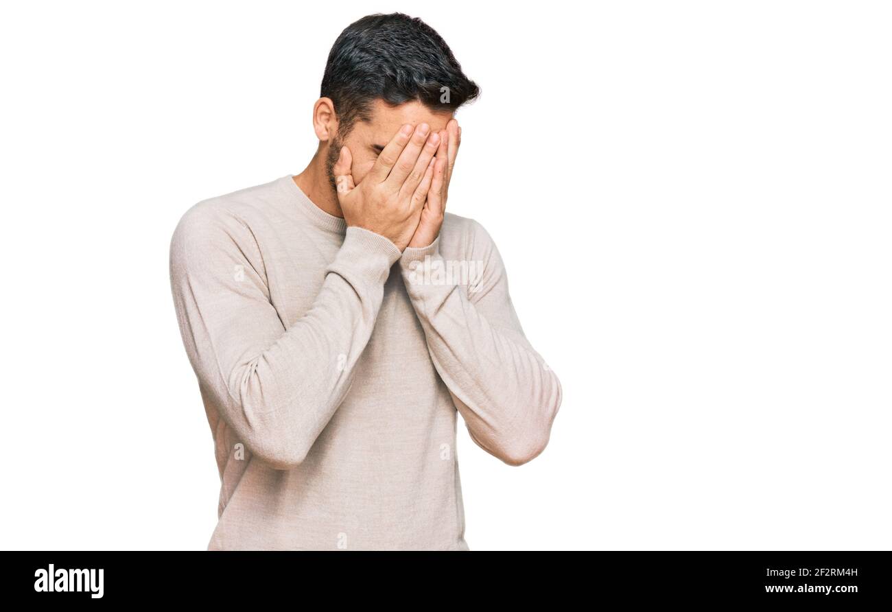 Young hispanic man wearing casual clothes with sad expression covering ...