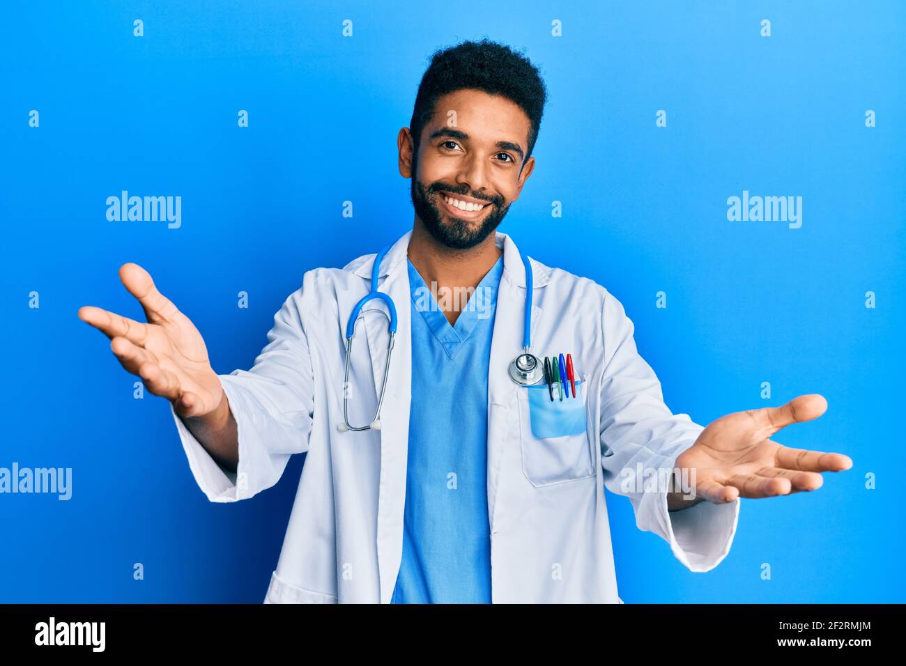 Handsome hispanic man with beard wearing doctor uniform and stethoscope ...