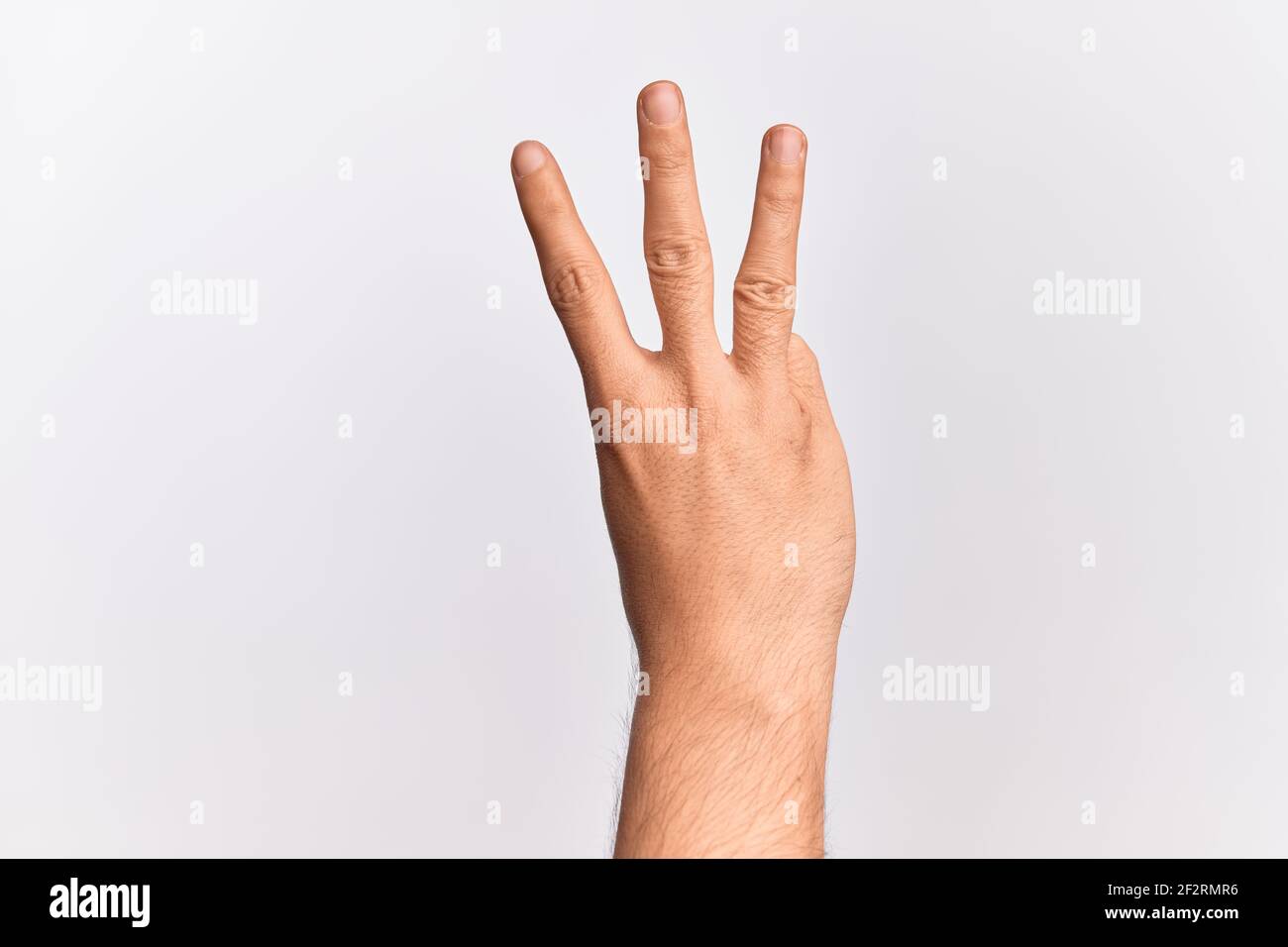 Hand of caucasian young man showing fingers over isolated white background counting number 3 ...