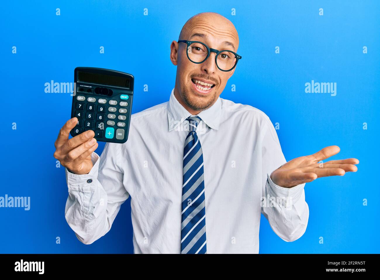 Bald business man with beard showing calculator device celebrating ...