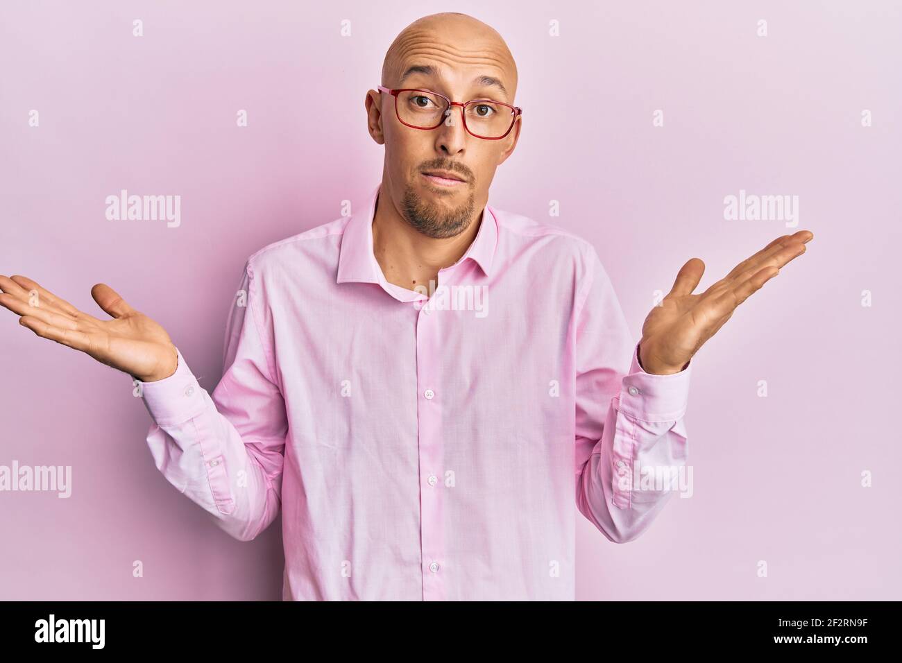 Bald man with beard wearing casual clothes and glasses clueless and ...