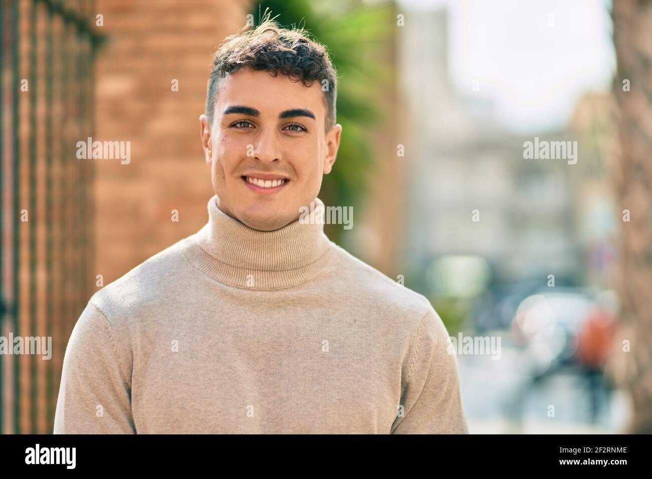 Young hispanic man smiling happy standing at the city Stock Photo - Alamy
