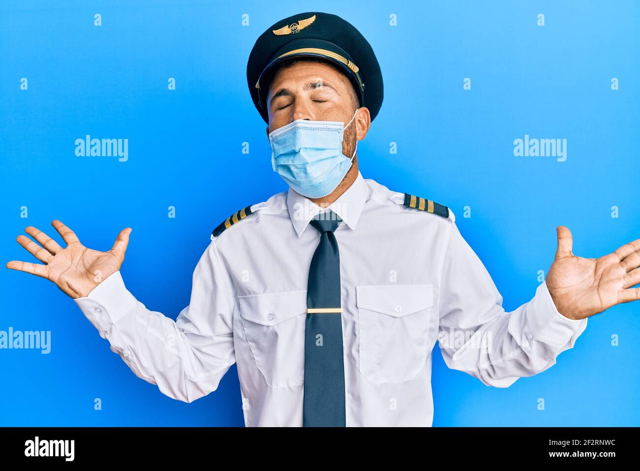 Handsome man with beard wearing airplane pilot uniform wearing safety ...