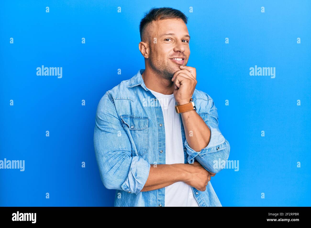 Handsome muscle man wearing casual denim jacket smiling looking ...
