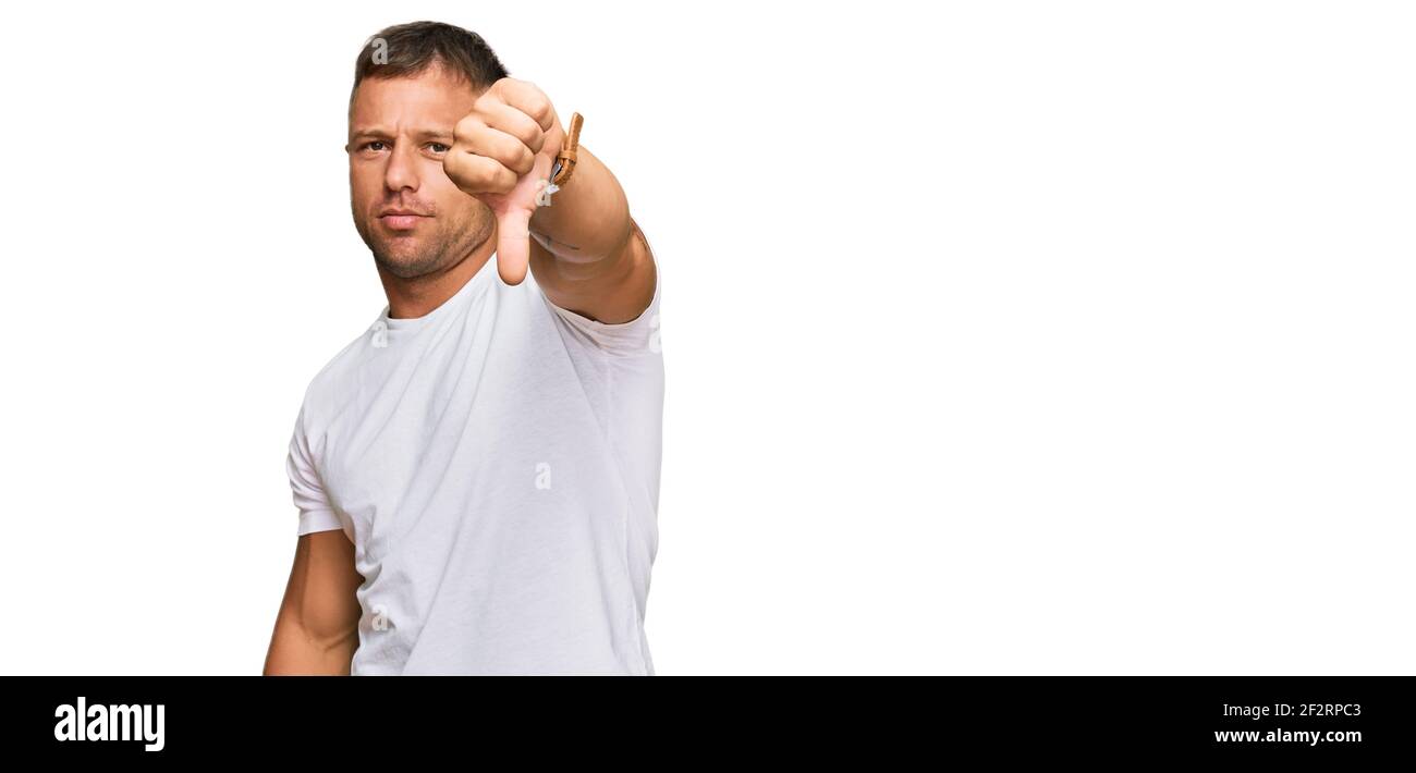 Handsome muscle man wearing casual white tshirt looking unhappy and ...