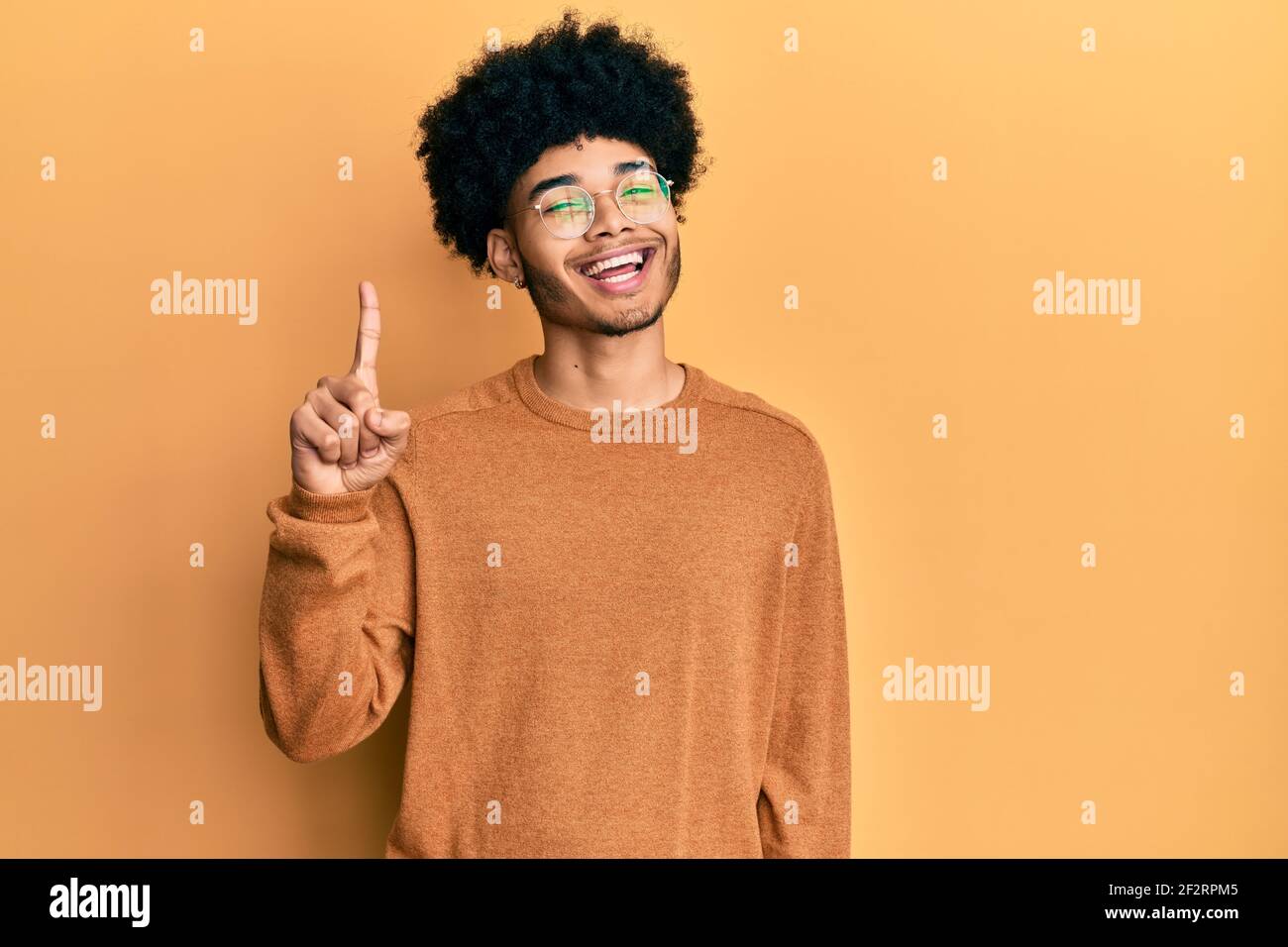 Young african american man with afro hair wearing casual winter sweater ...