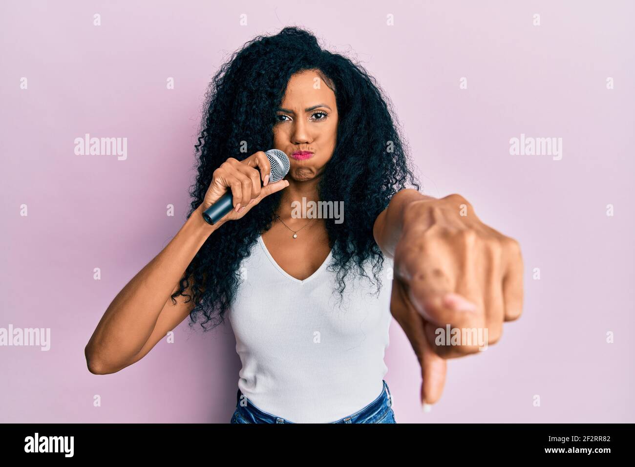 Middle age african american woman singing song using microphone ...