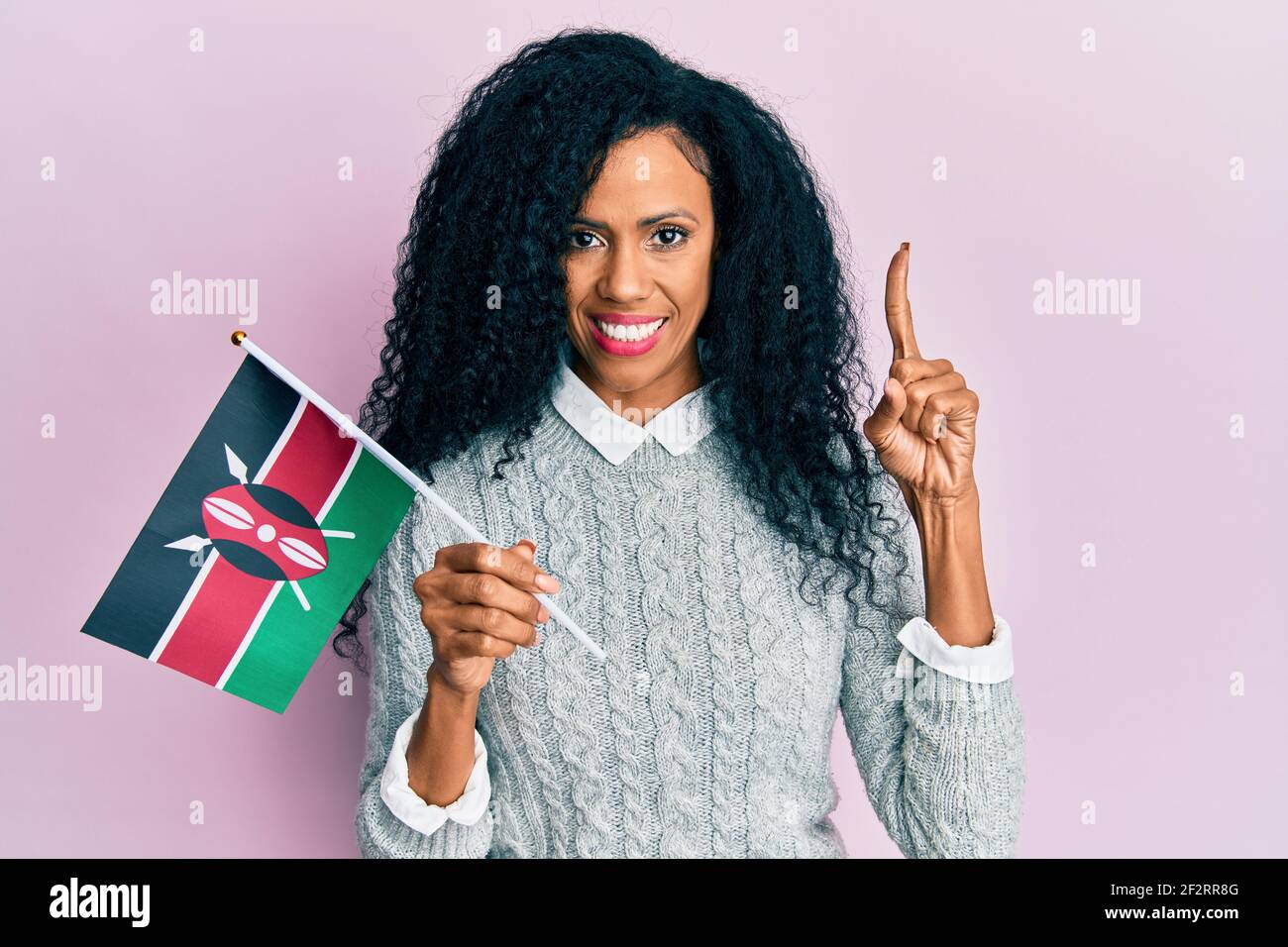 Middle age african american woman holding kenya flag smiling with an ...
