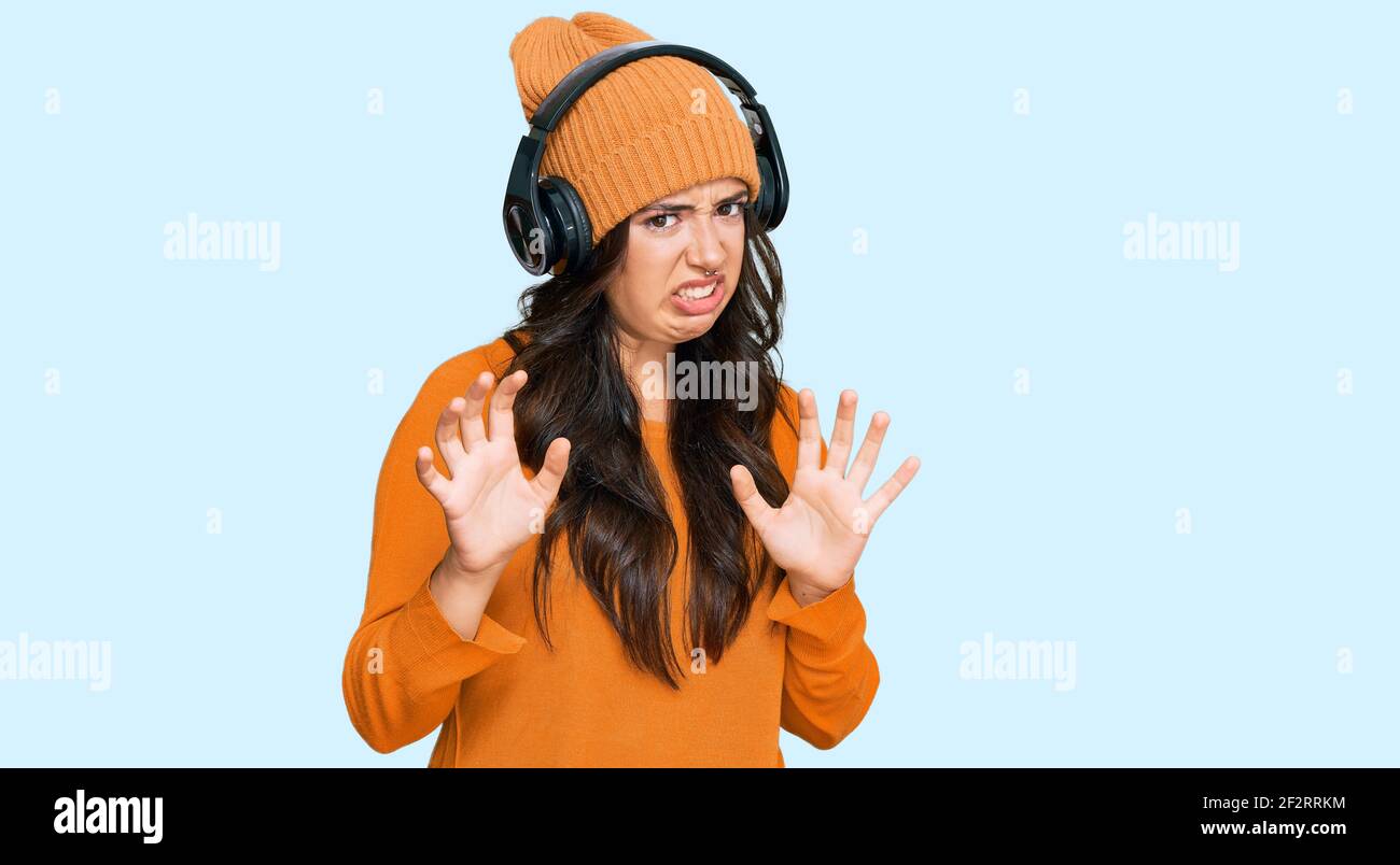 Beautiful brunette young woman listening to music using headphones ...