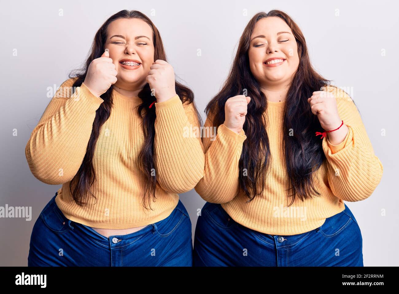 Young plus size twins wearing casual clothes excited for success with ...