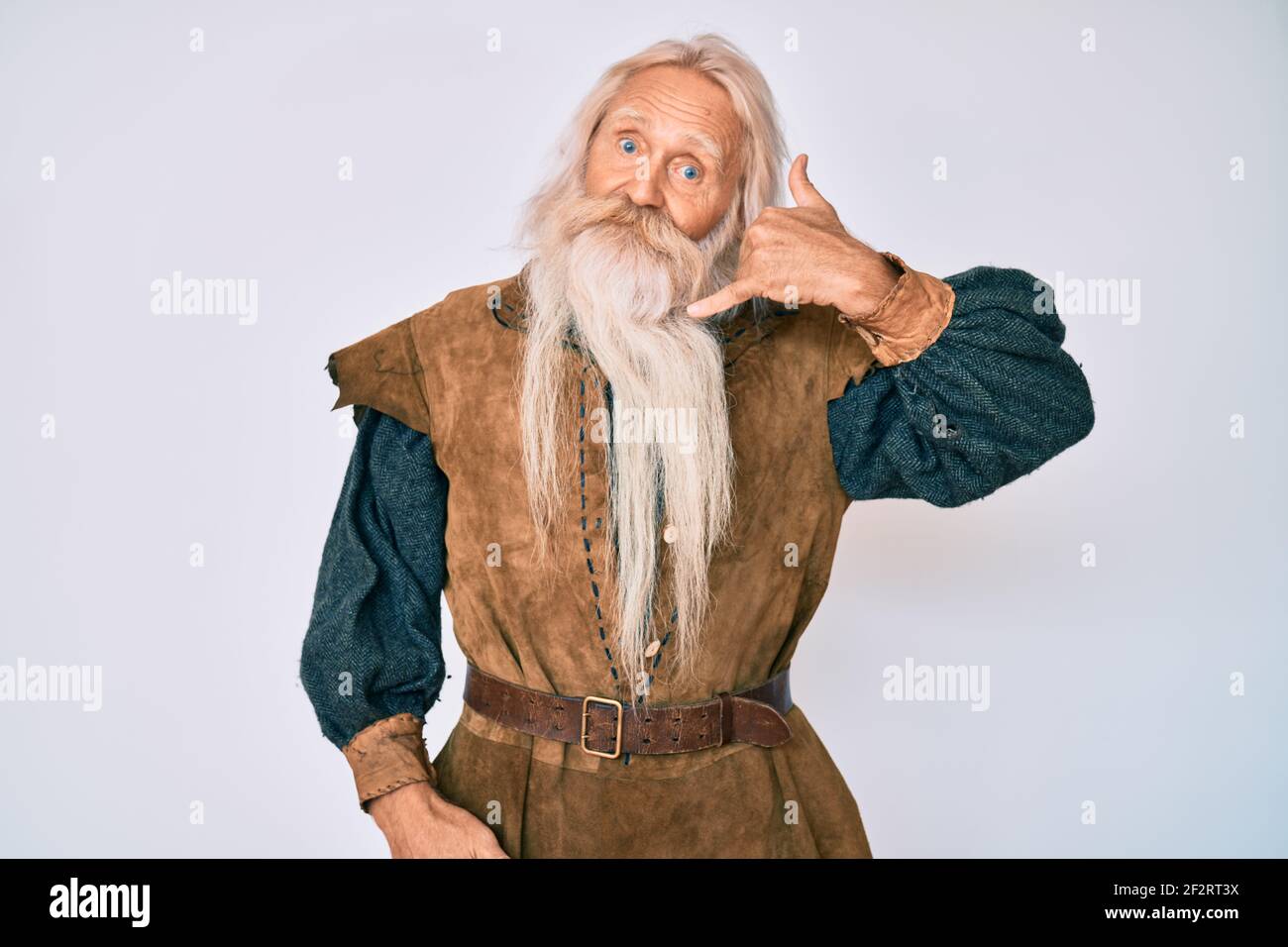 Old senior man with grey hair and long beard wearing viking traditional ...