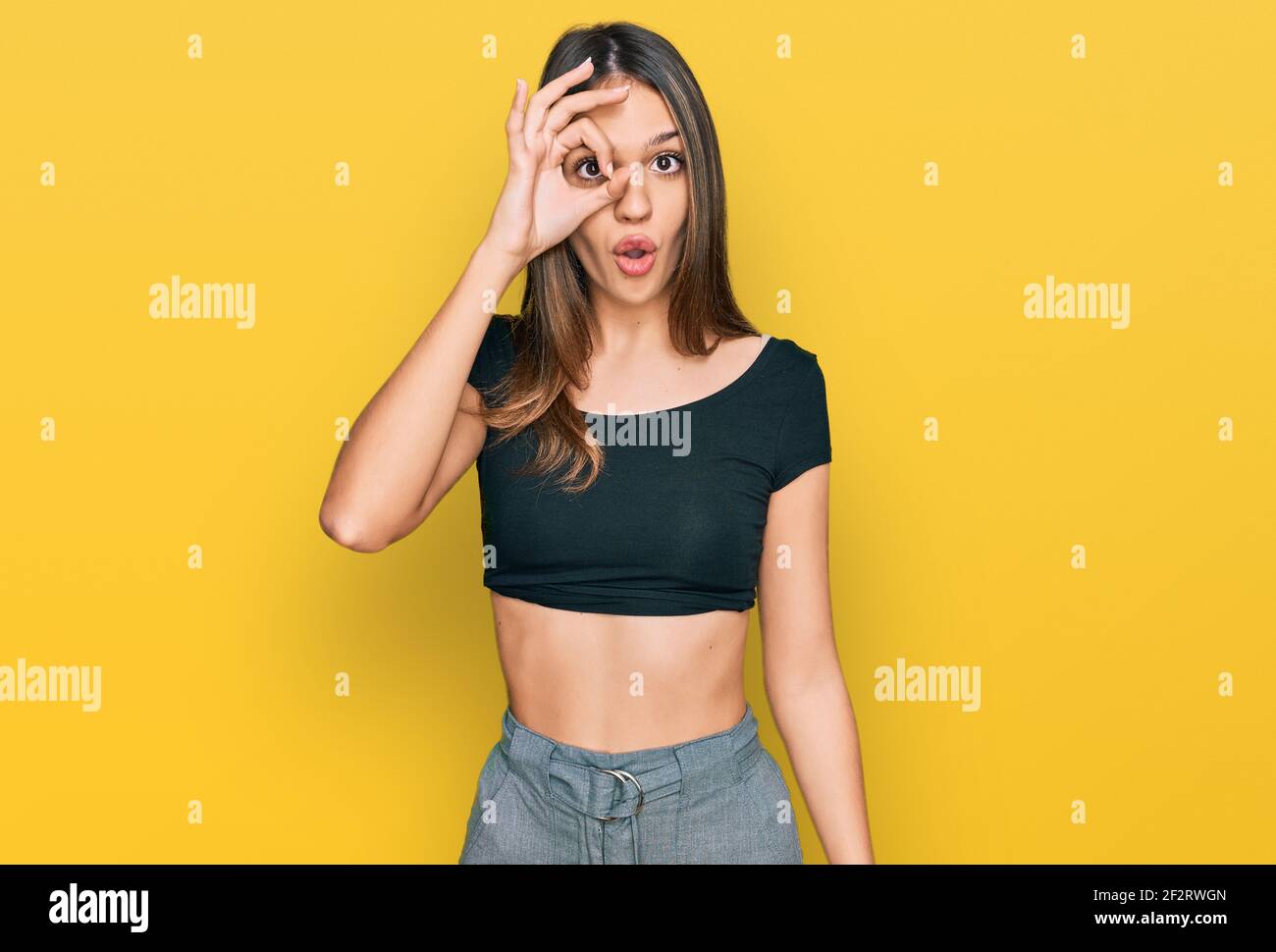Young brunette woman wearing casual clothes doing ok gesture shocked ...