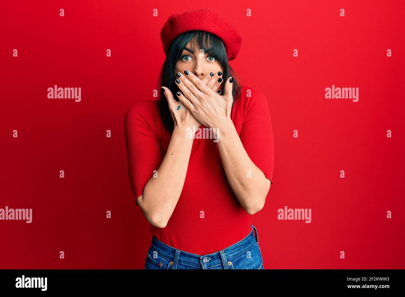 Young hispanic woman wearing french look with beret shocked covering ...