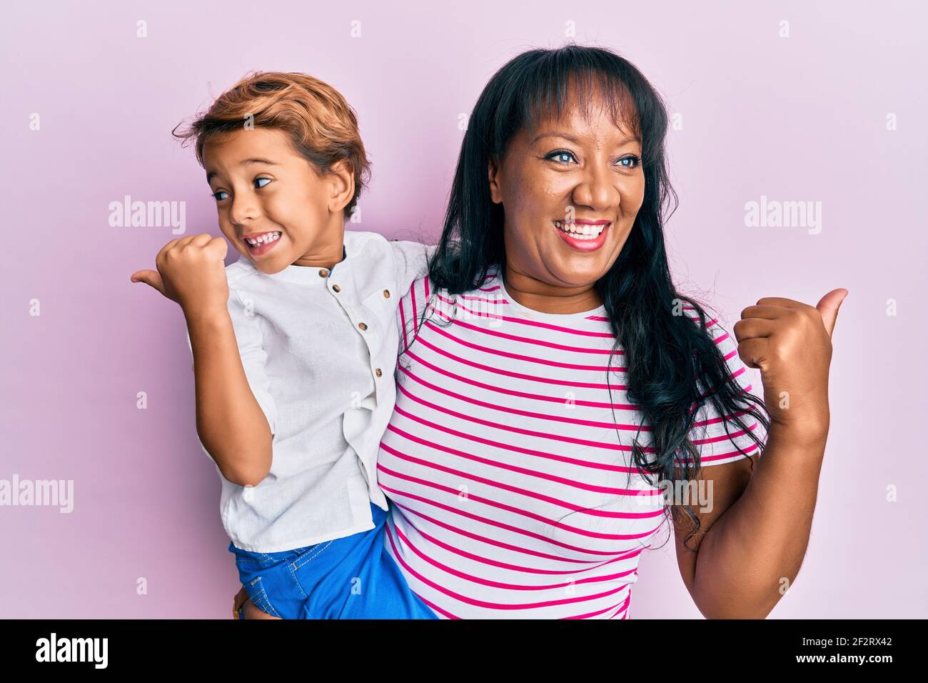 Hispanic family of mother and son hugging together with love pointing ...