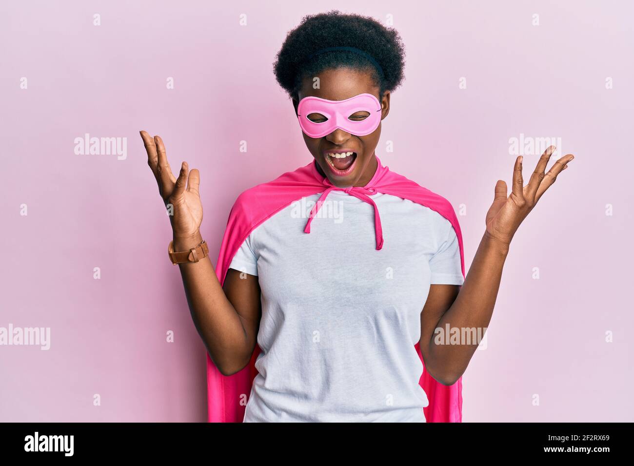 Young african american girl wearing superhero mask and cape costume ...