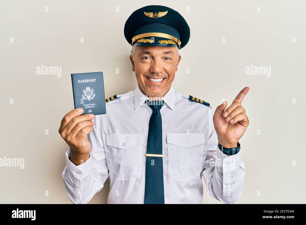 Handsome middle age mature pilot man holding usa passport smiling happy ...