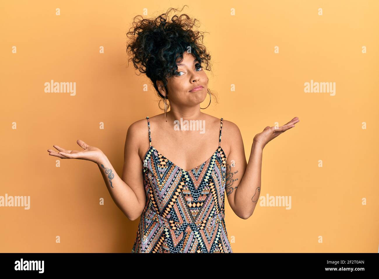 Young hispanic woman wearing casual clothes clueless and confused with ...