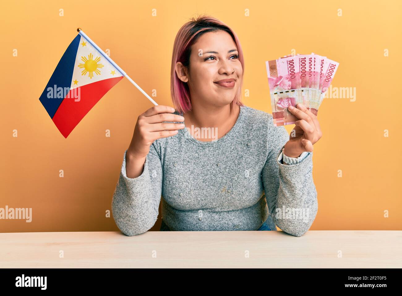 Hispanic woman with pink hair holding philippine flag and philippines ...