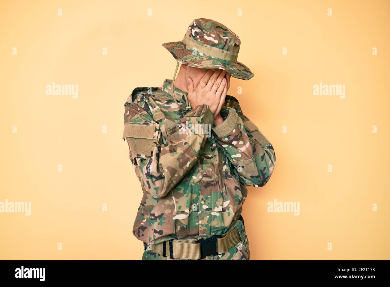 Young handsome man wearing camouflage army uniform with sad expression ...