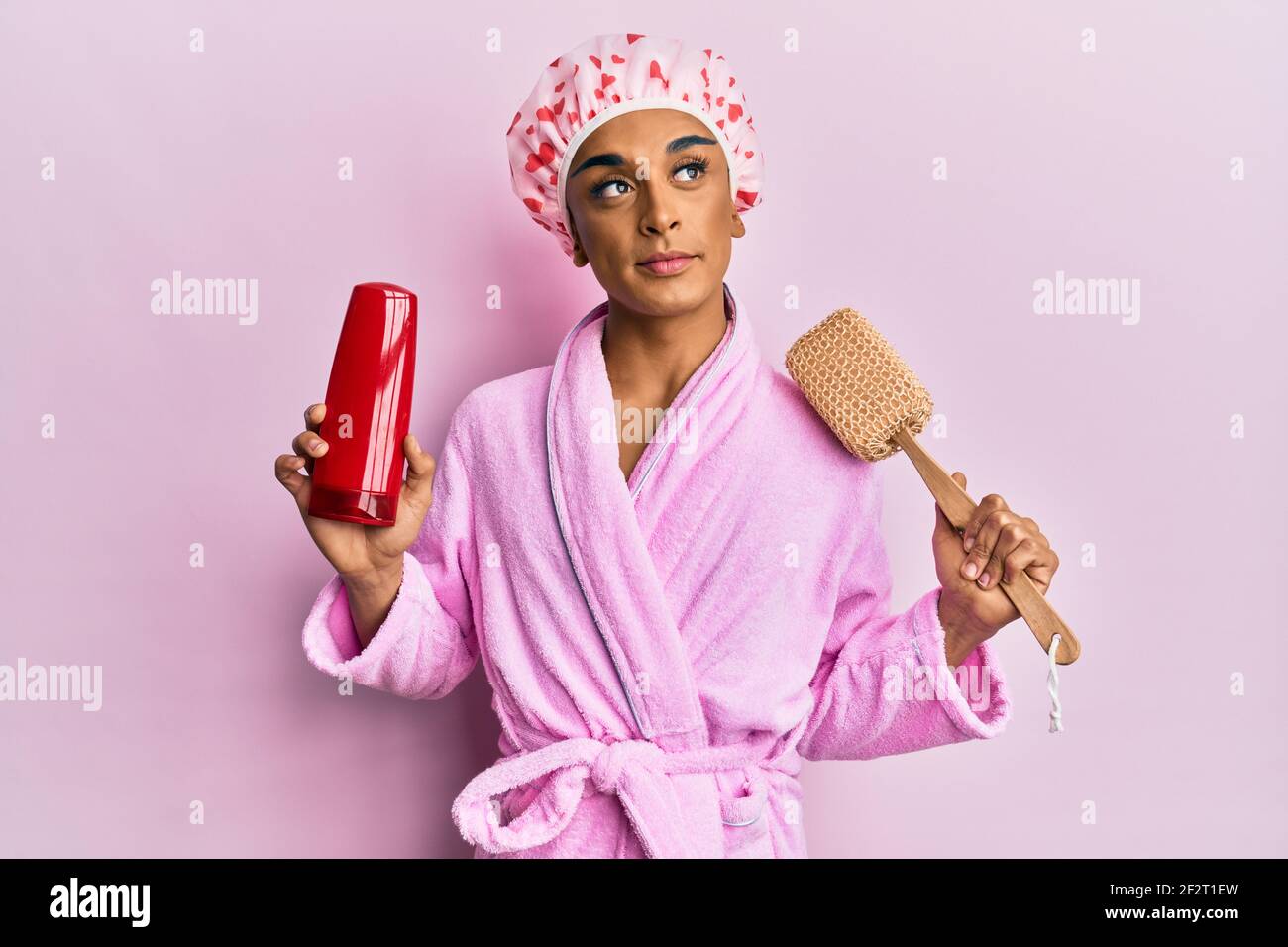 Hispanic man wearing make up wearing shower cap holding sponge and ...