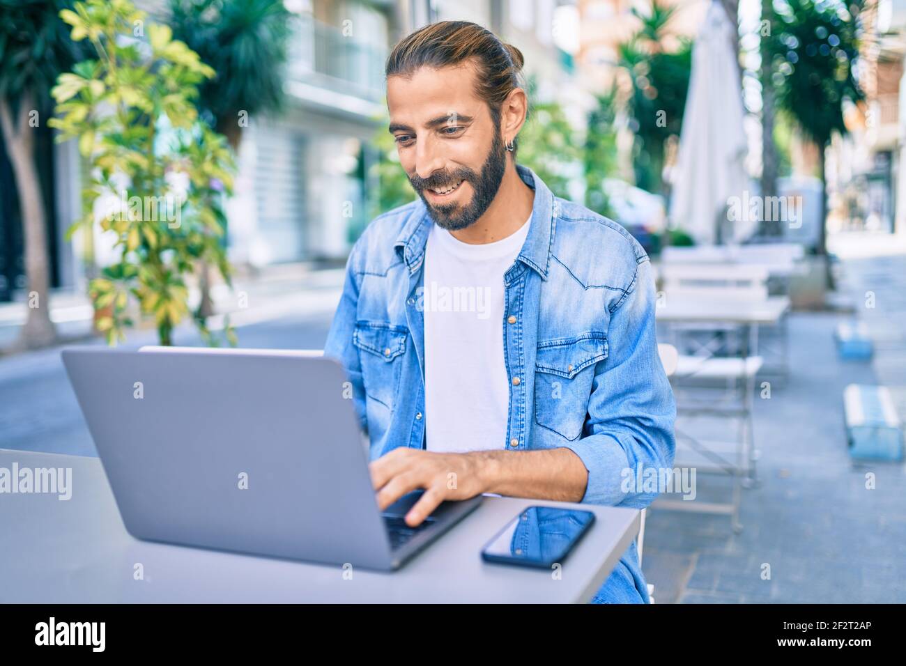 Young middle eastern man smiling happy working using laptop at coffee ...