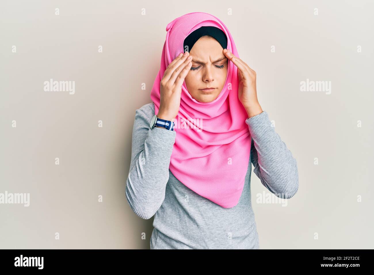 Young caucasian woman wearing traditional islamic hijab scarf with hand ...