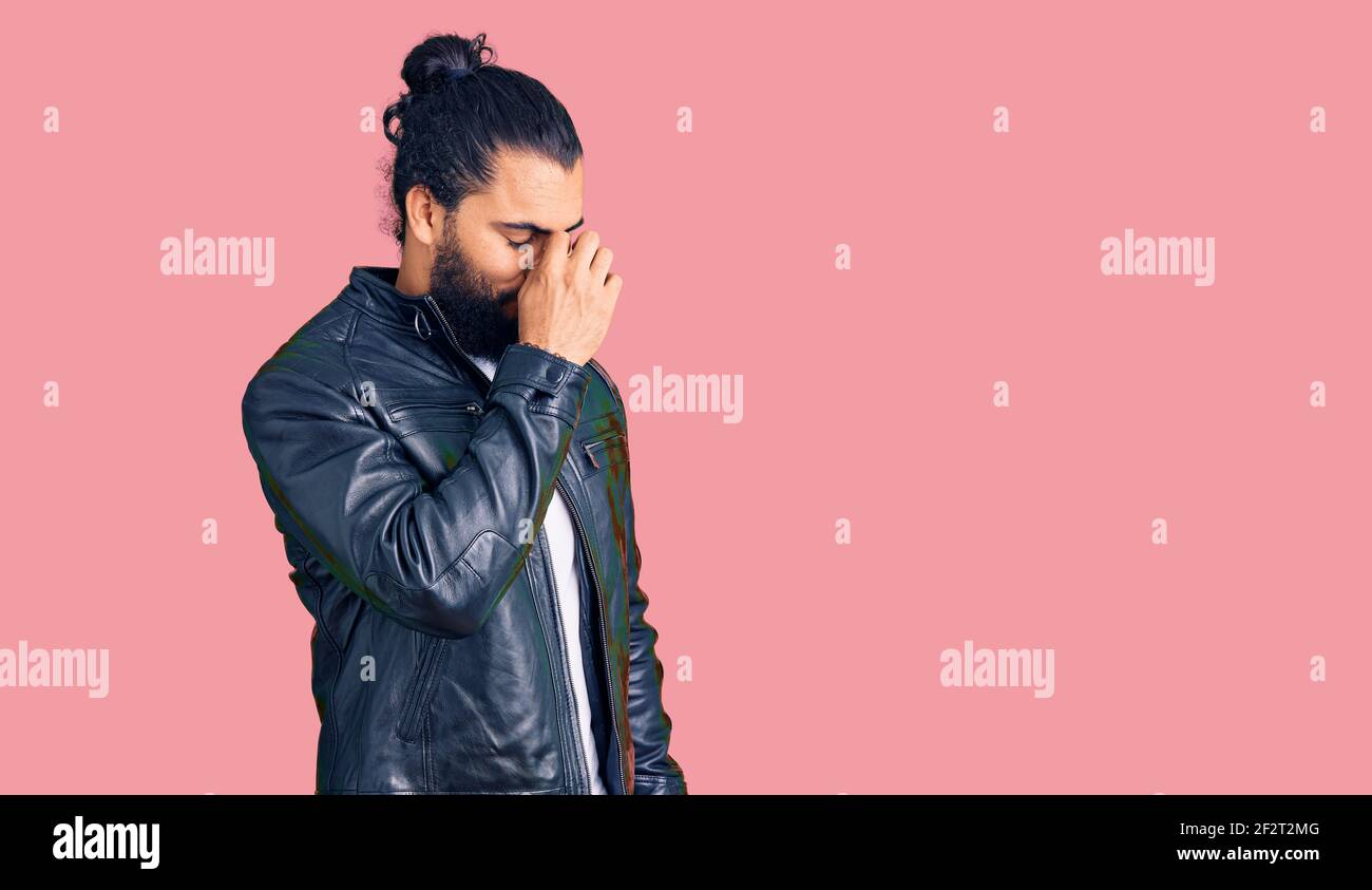 Young arab man wearing casual leather jacket tired rubbing nose and ...